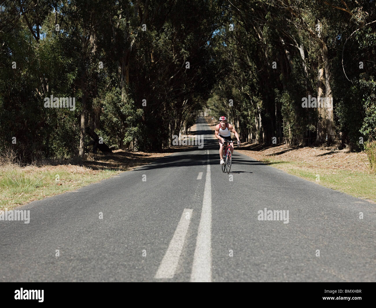 Young man cycling on road Stock Photo - Alamy