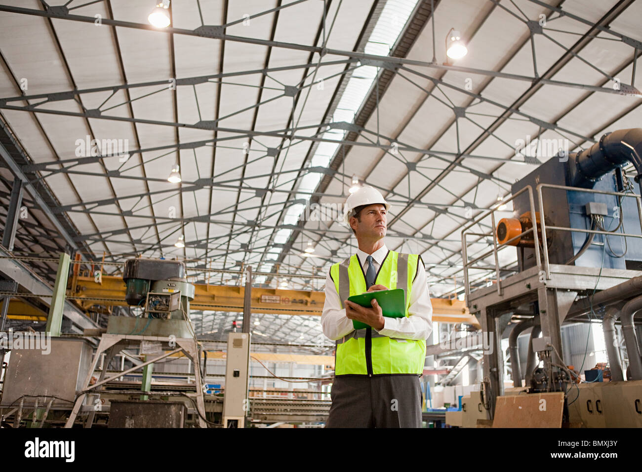 Mature man with clipboard in factory Stock Photo - Alamy