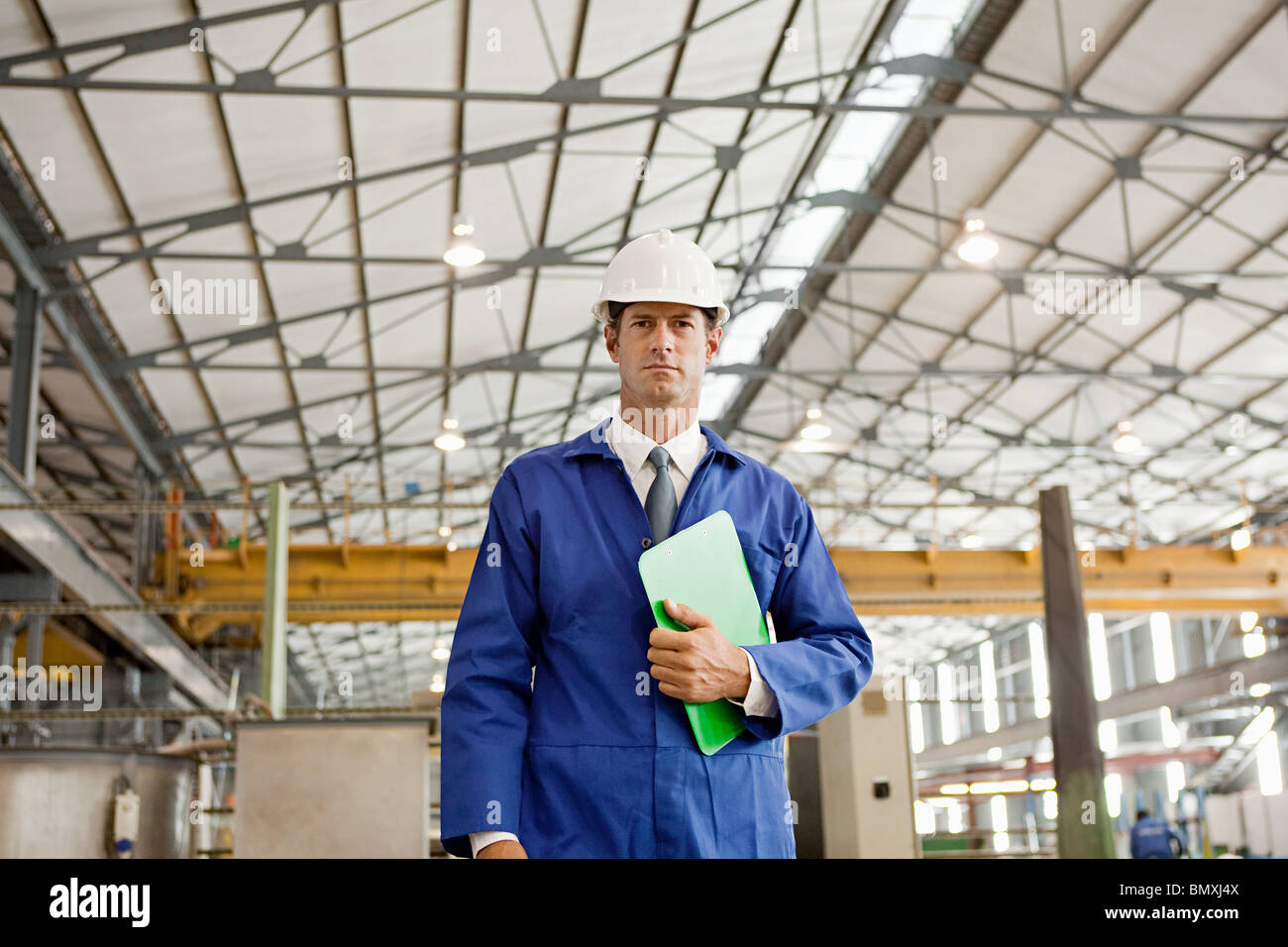 Mature man with clipboard in factory Stock Photo - Alamy