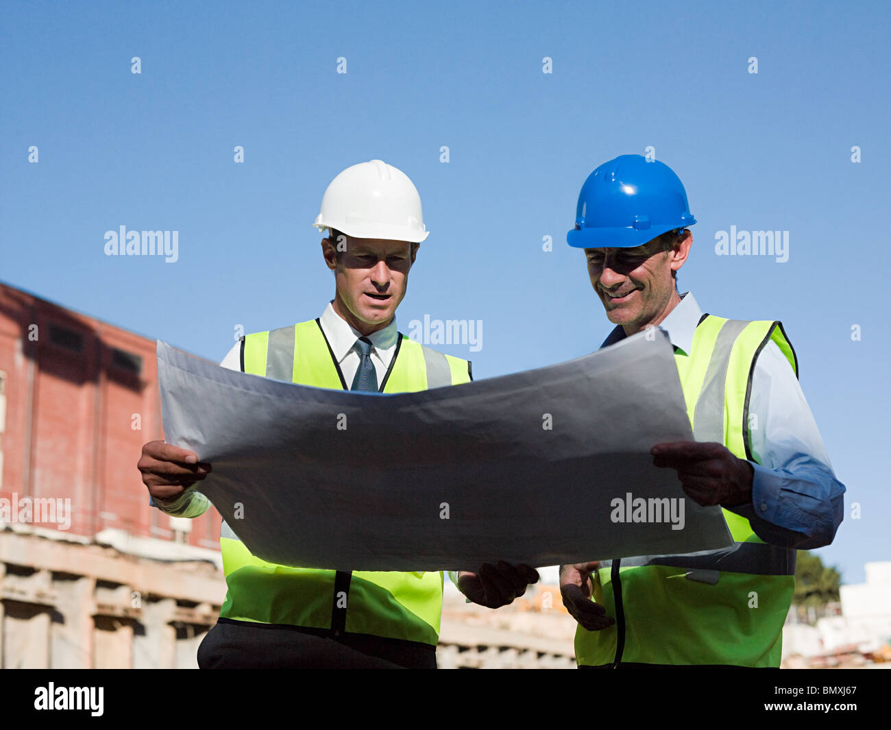 Mature men inspecting blueprints on construction site Stock Photo - Alamy