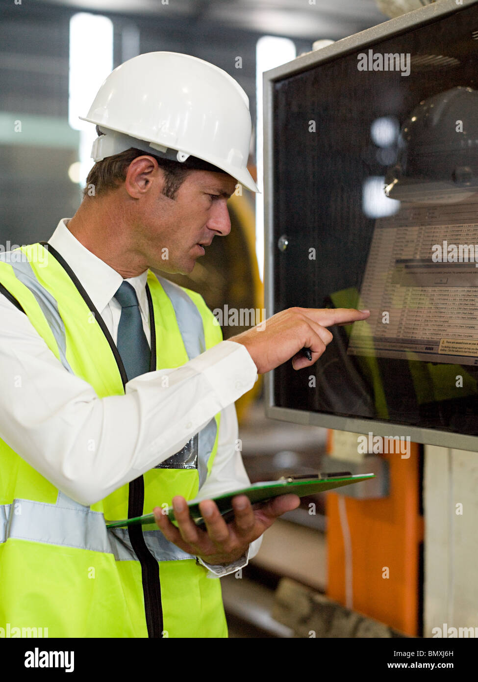 Mature man inspecting factory equipment Stock Photo - Alamy