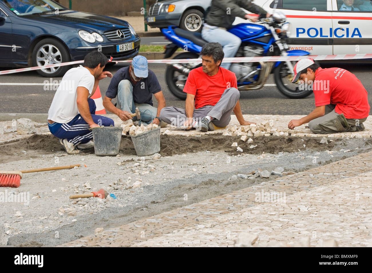 Group of men working worker workers people on the intricate paving on ...