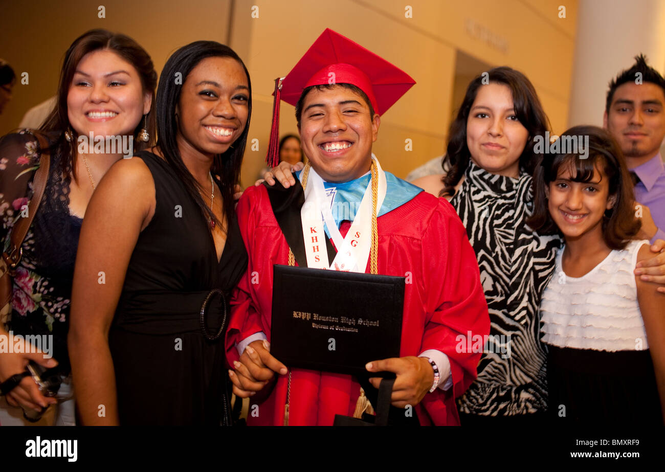 Hispanic male graduate poses with family and friends after graduation ...