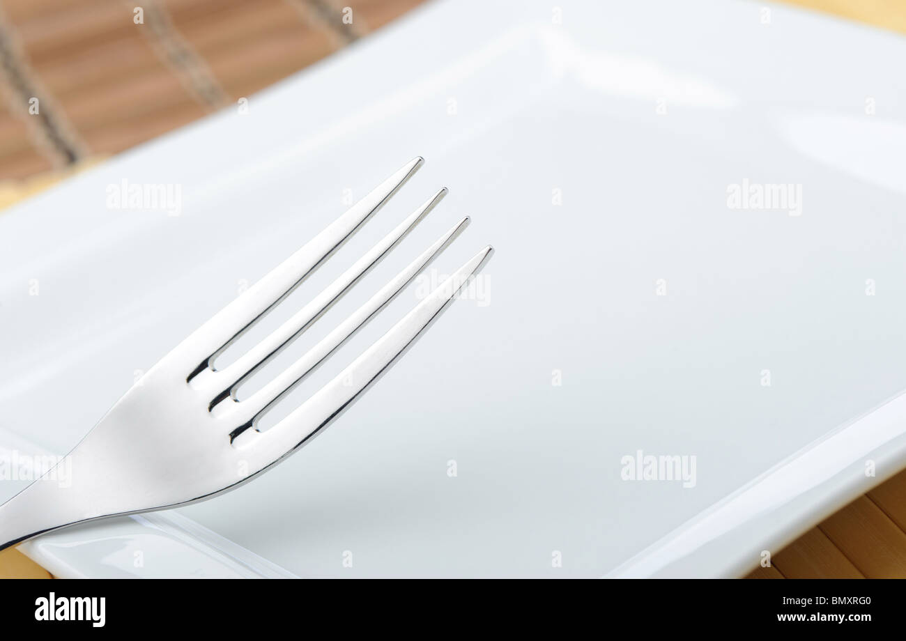 Fork laying on a plate. A photo close up Stock Photo - Alamy