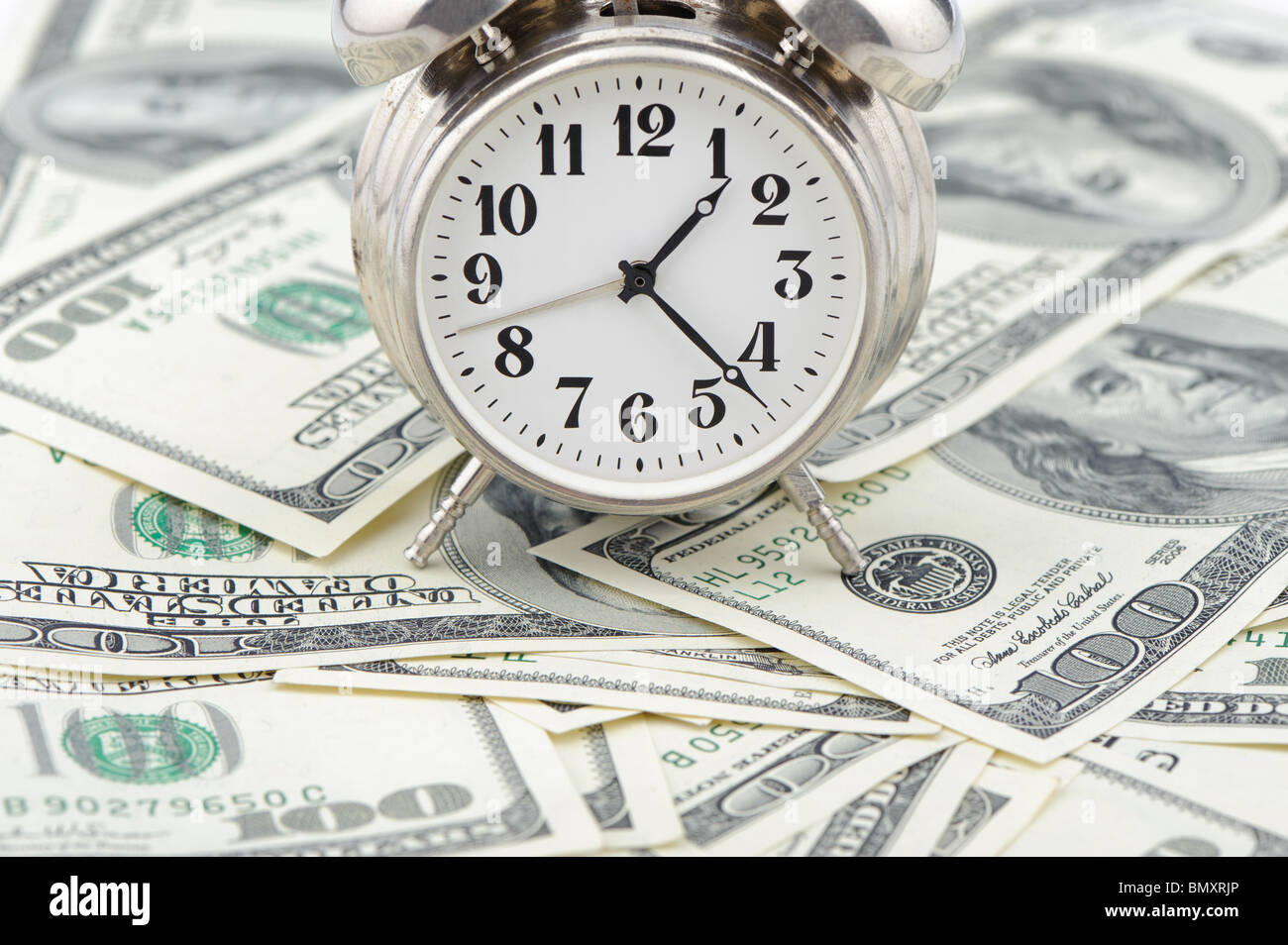 Time - money. Business concept. Analog hours on a heap of paper dollars ...