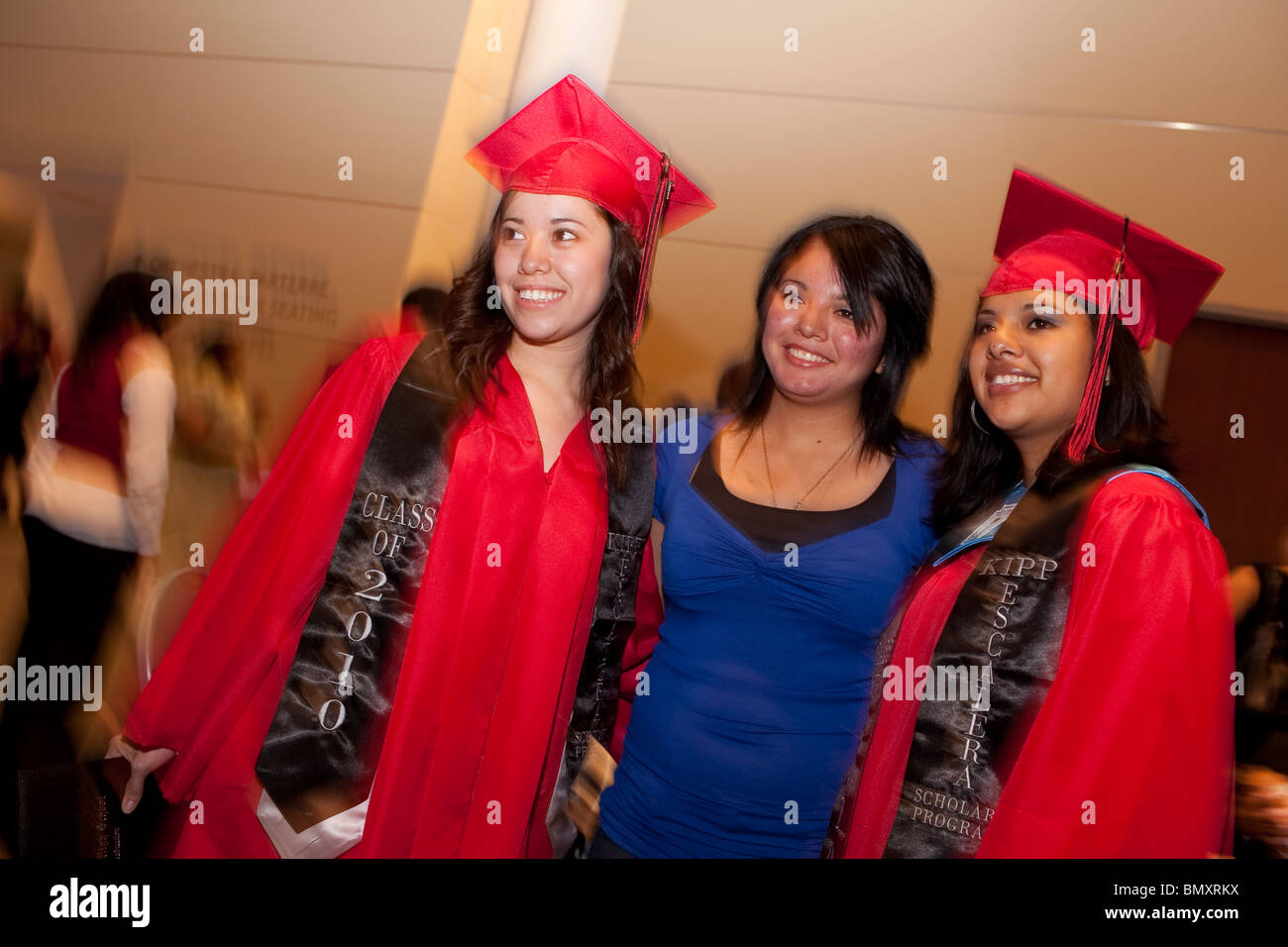 Two female graduates pose with a guest after graduation ceremony for ...