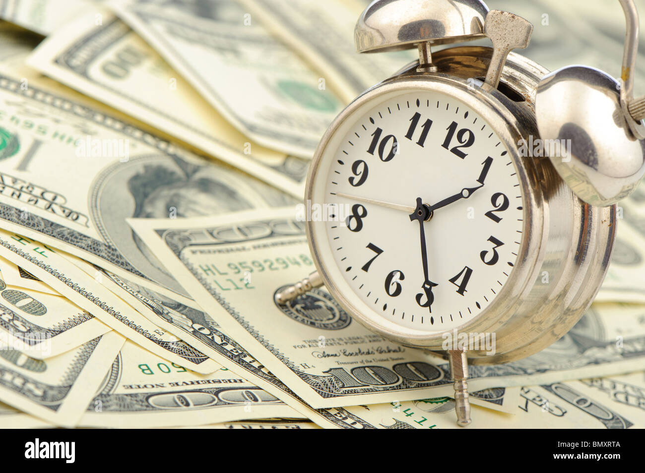 Time - money. Business concept. Analog hours on a heap of paper dollars ...