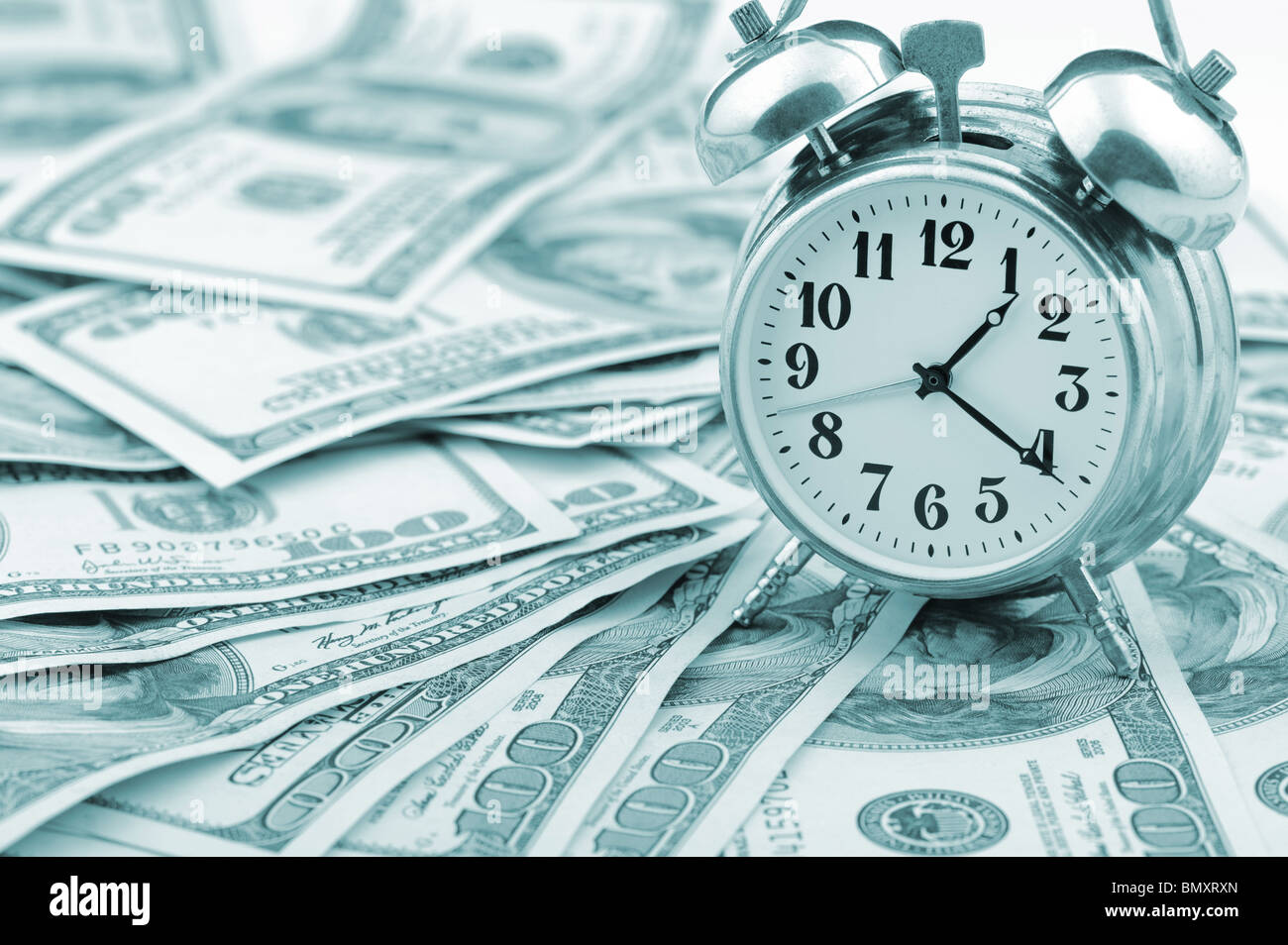 Time - money. Business concept. Analog hours on a heap of paper dollars ...