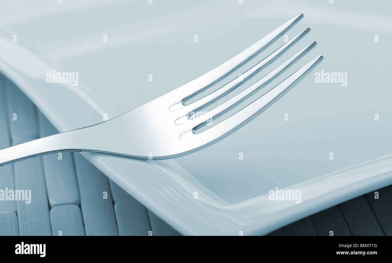 Fork laying on a plate. A photo close up Stock Photo - Alamy