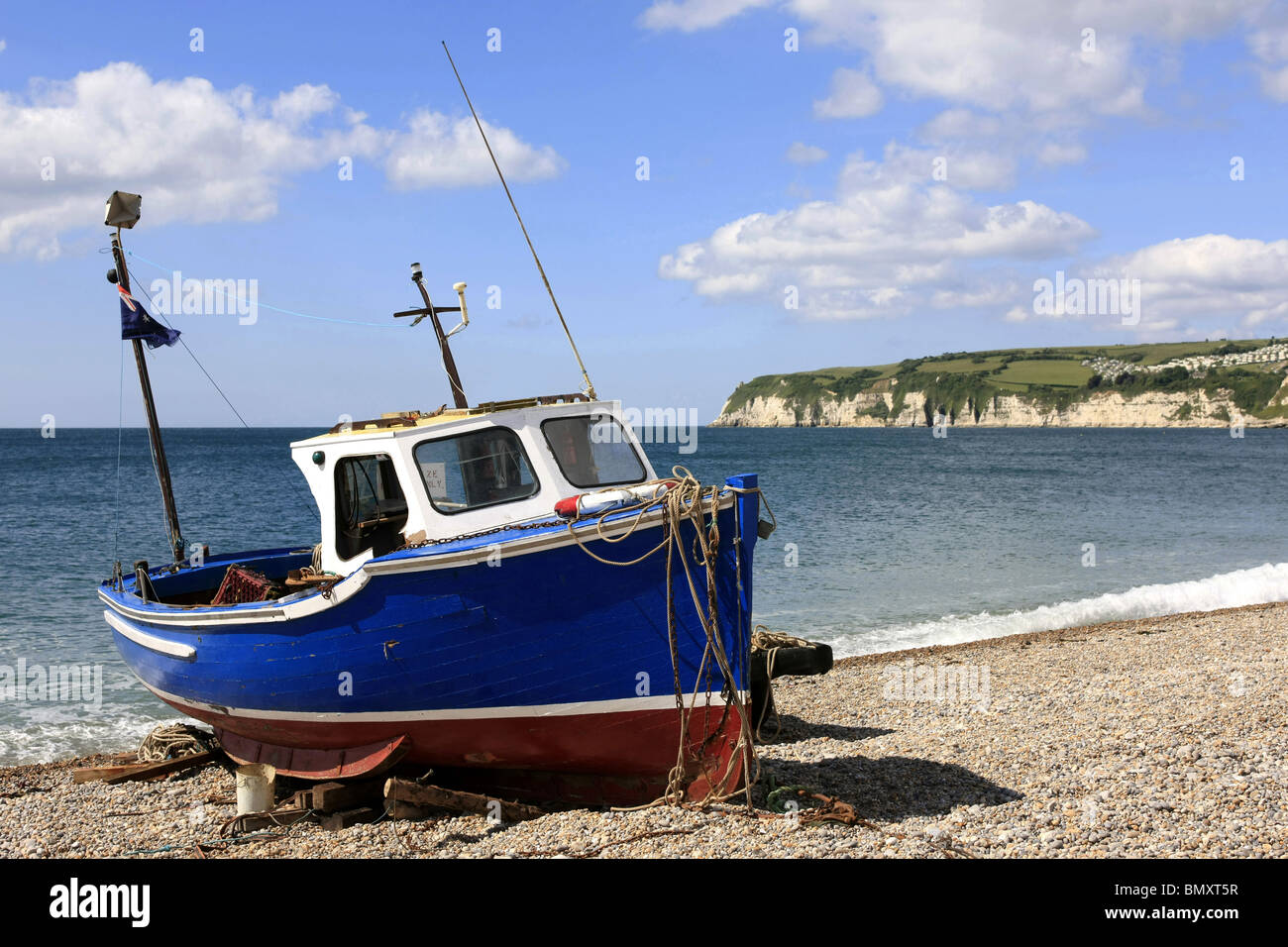 A fishing boat hauled onto the beach at Seaton in Devon England Stock ...