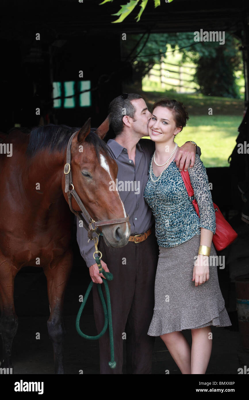 young couple with horse in barn Stock Photo - Alamy