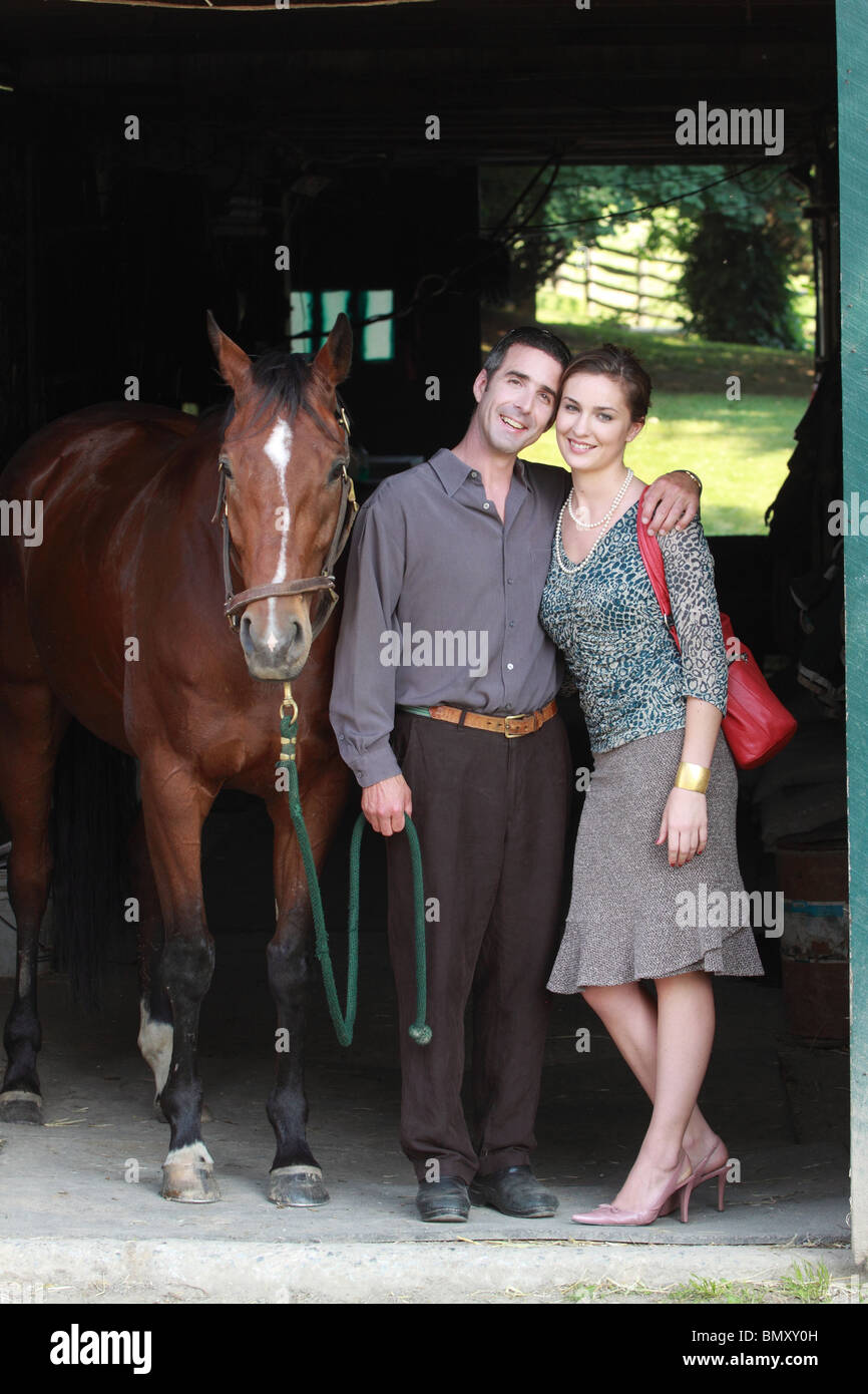 young couple with horse in barn Stock Photo - Alamy