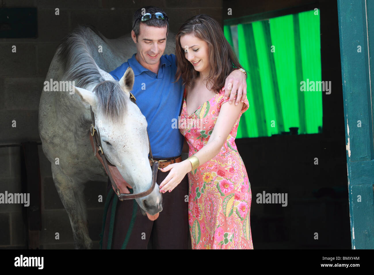 romantic couple with horse in barn Stock Photo - Alamy