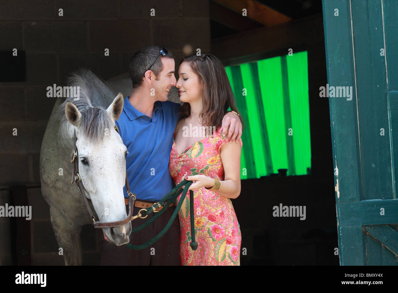 romantic couple with horse in barn Stock Photo - Alamy