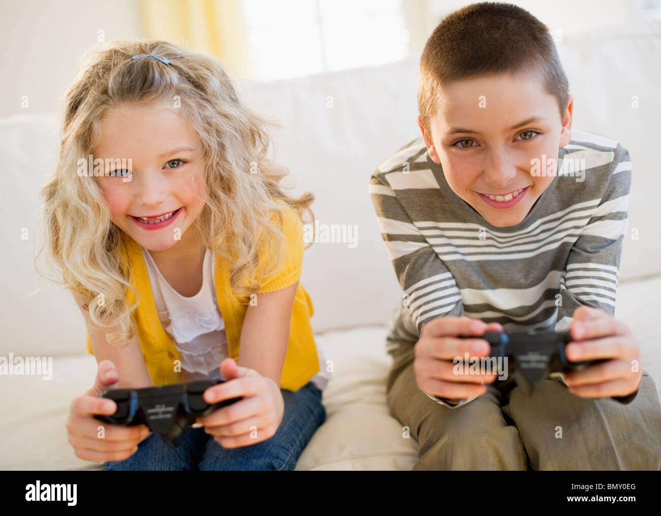 Siblings playing video game Stock Photo - Alamy