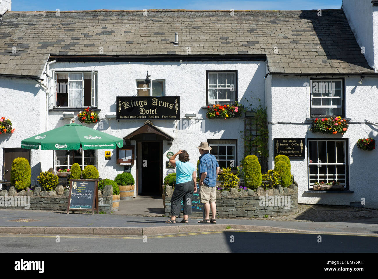 Couple outside the Kings Arms Hotel in the village of Hawkshead, Lake ...