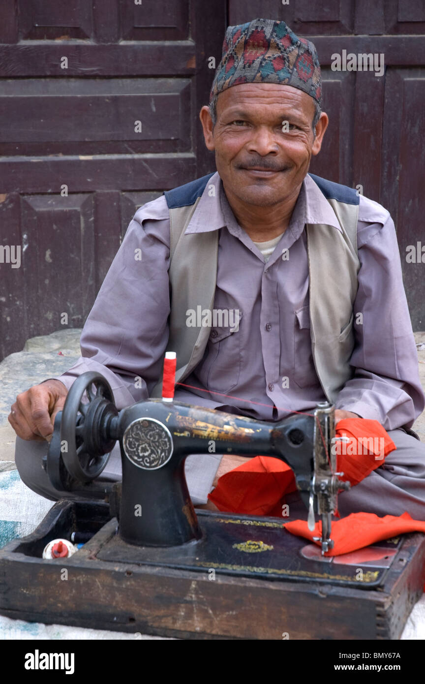 An friendly old man with his sewing machine does mending and sewing on ...