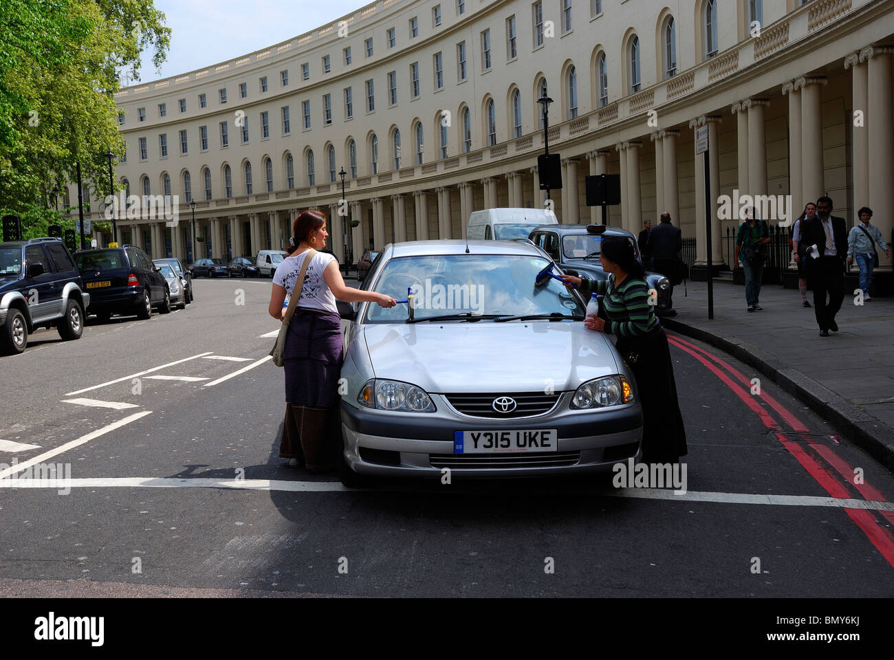 Women cleaning car windscreen at traffic lights in London Stock Photo ...