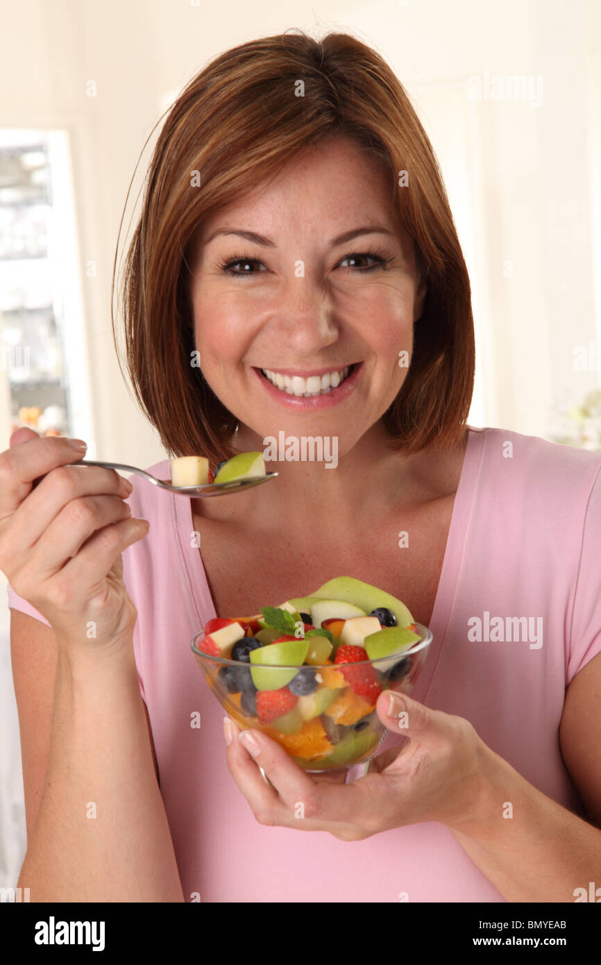 WOMAN EATING FRESH FRUIT SALAD Stock Photo - Alamy