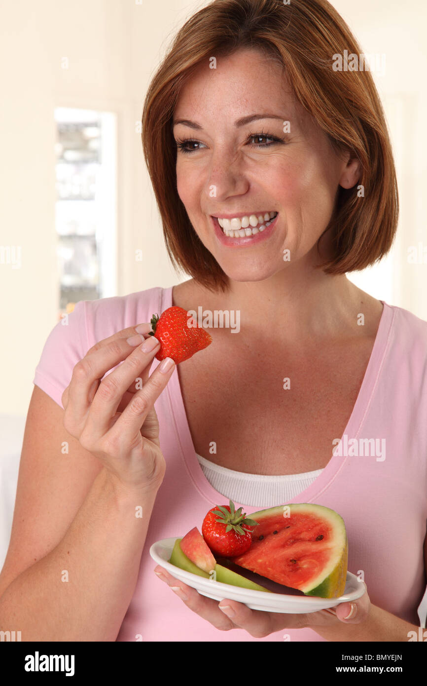 WOMAN EATING FRESH FRUIT SALAD Stock Photo - Alamy