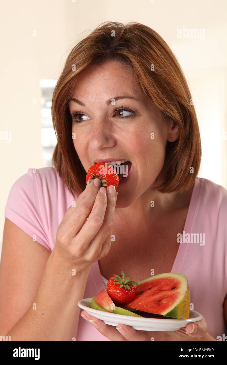 WOMAN EATING FRESH FRUIT SALAD Stock Photo - Alamy