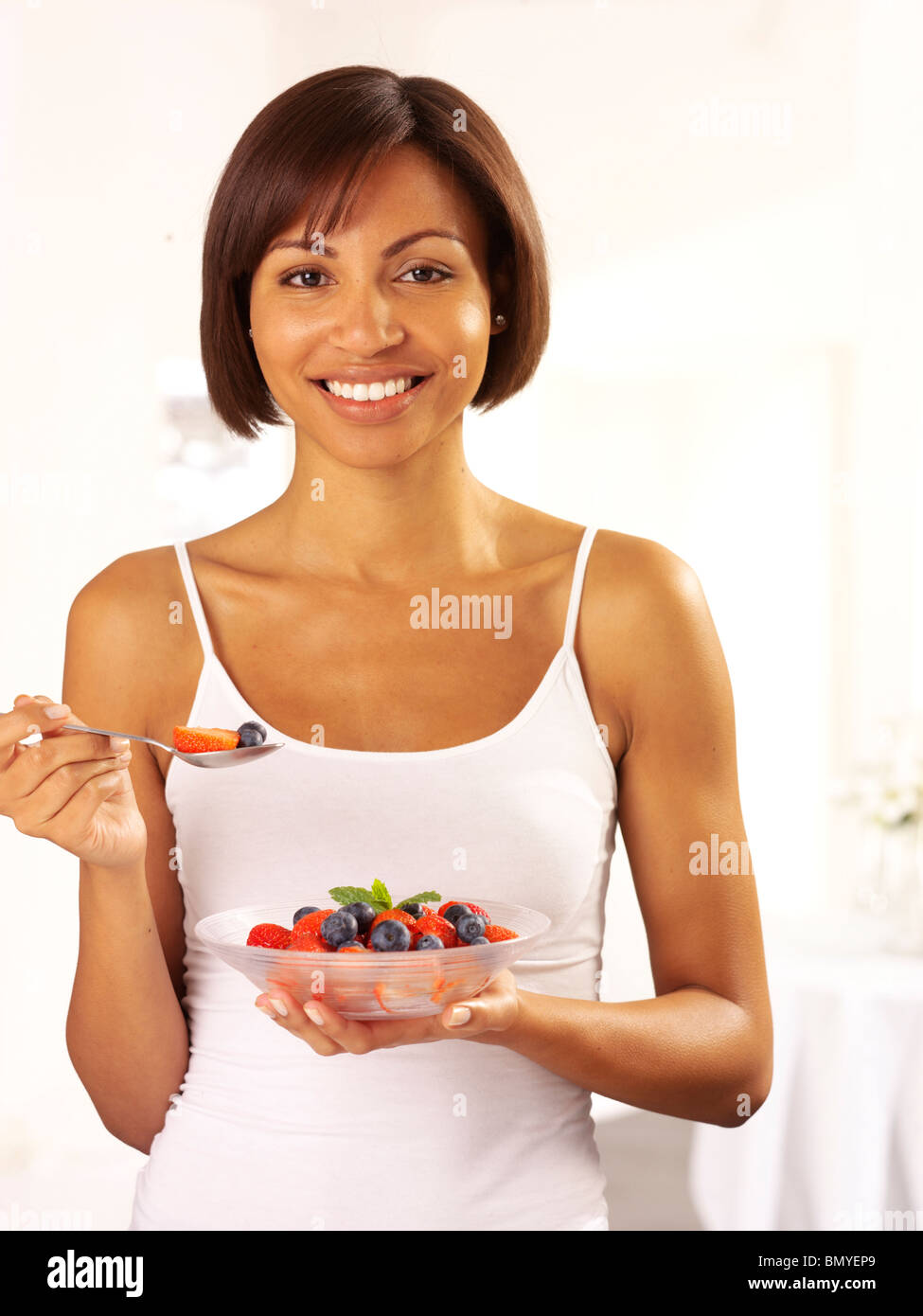 WOMAN EATING FRESH FRUIT SALAD Stock Photo - Alamy