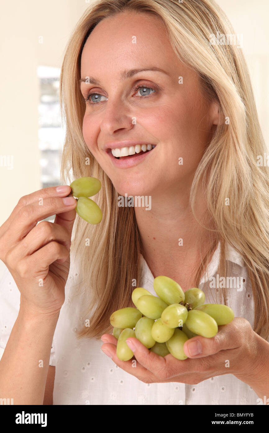 WOMAN EATING GRAPES Stock Photo - Alamy