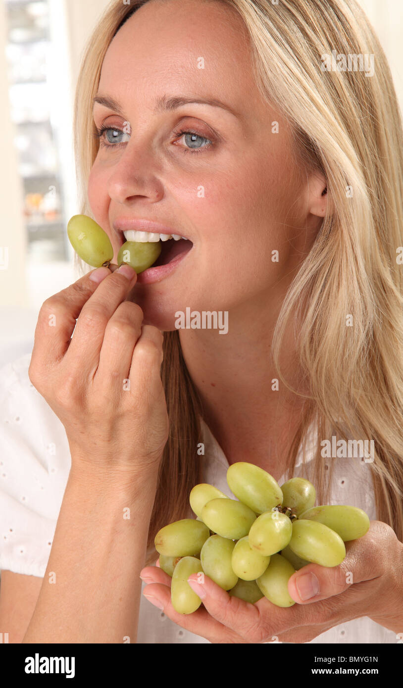 WOMAN EATING GRAPES Stock Photo - Alamy