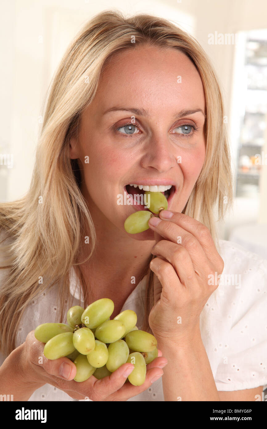 Woman eating grapes hi-res stock photography and images - Alamy