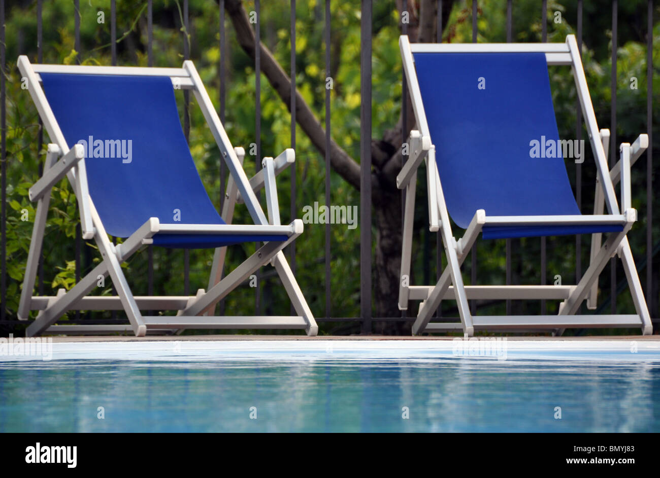 Two comfortable chairs at a great blue pool Stock Photo - Alamy
