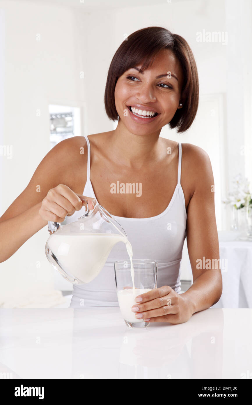 WOMAN POURING MILK INTO GLASS Stock Photo - Alamy