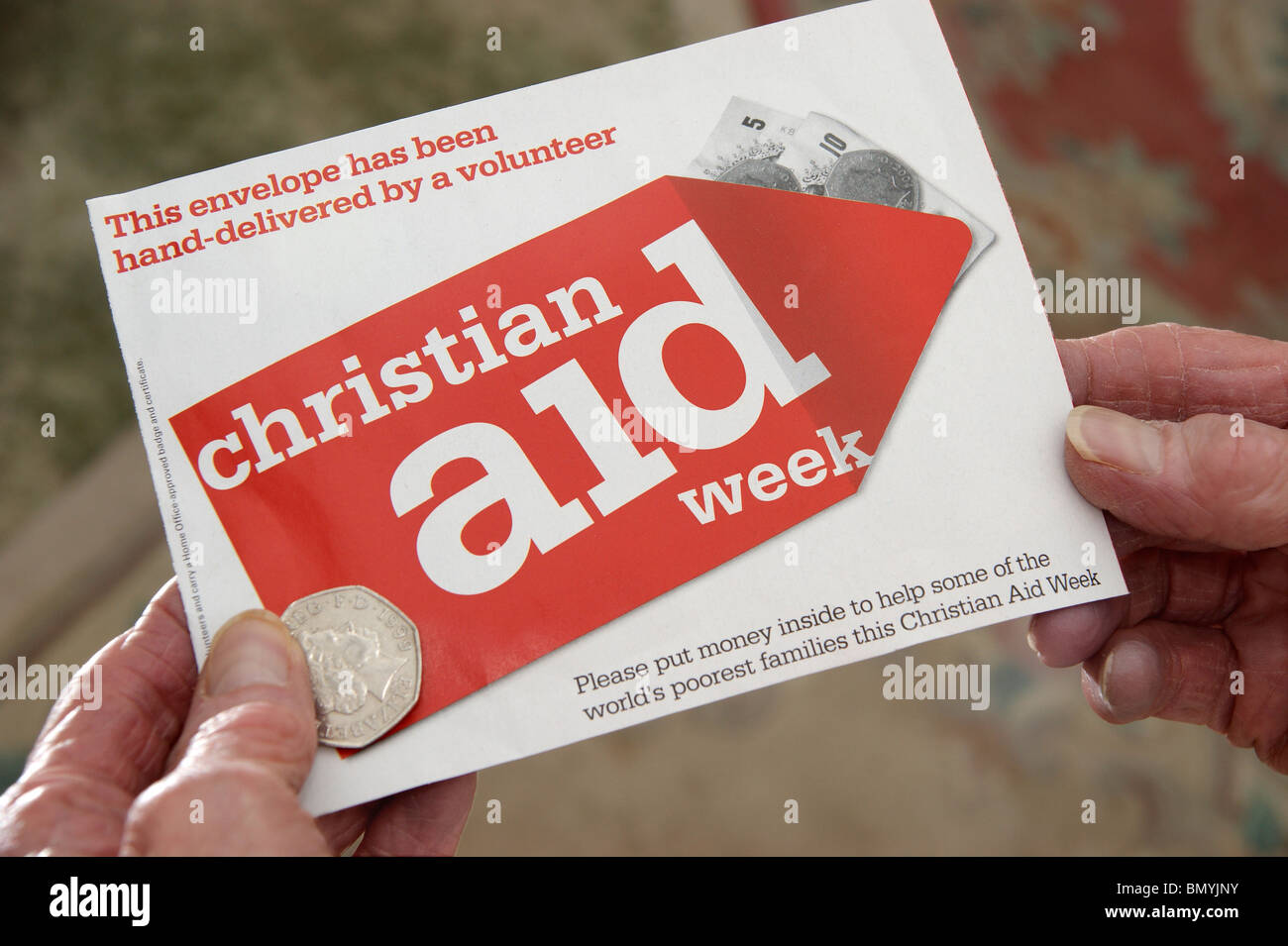 woman holding donation of a coin for a charity collecting envelope for ...