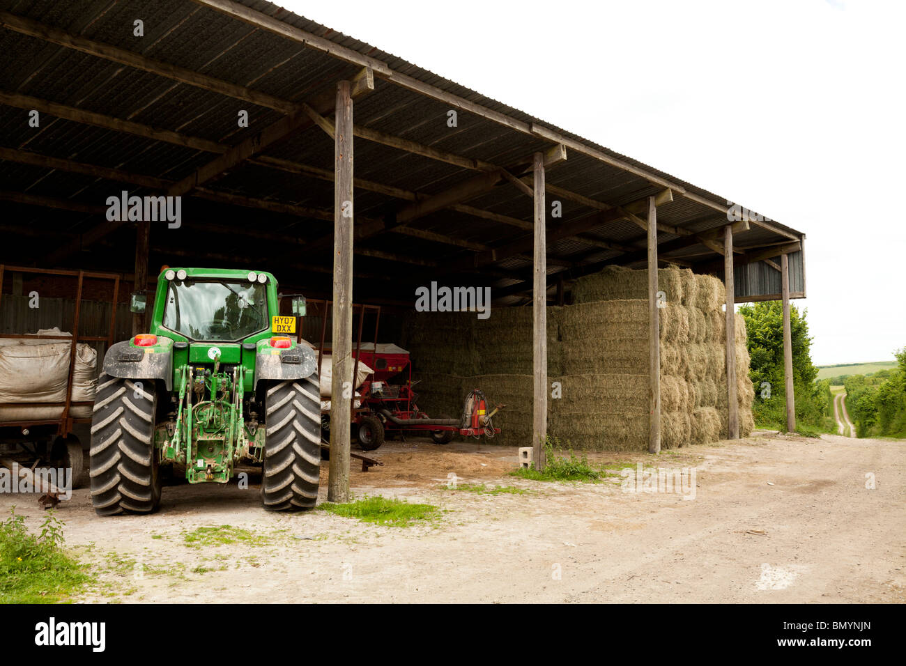 Open fronted farm barn with tractor and hay bales Stock Photo - Alamy