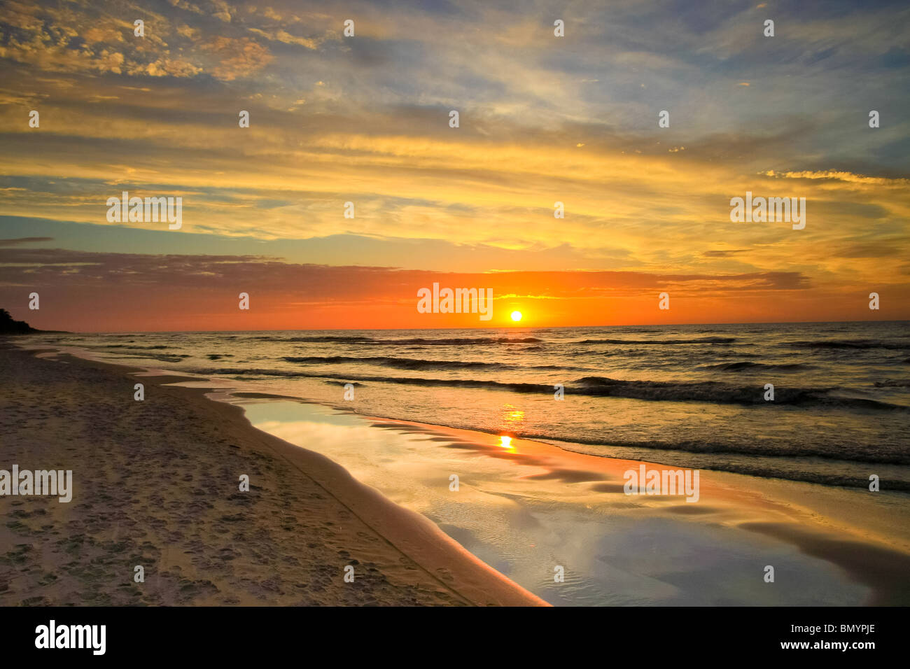 Sunset landscape on Baltic sea beach with heavy and surreal clouds ...