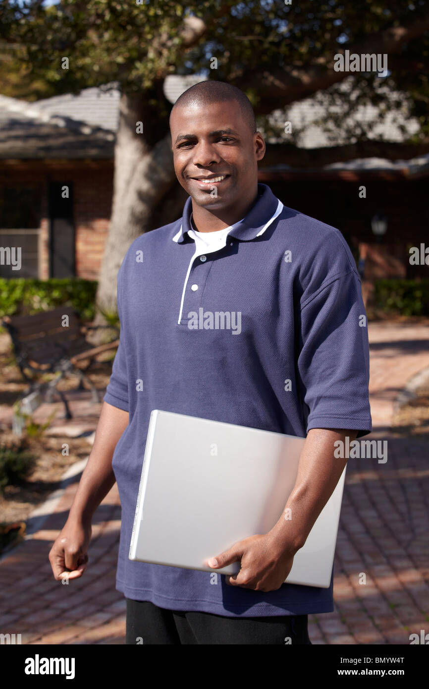 Black man carrying laptop Stock Photo - Alamy