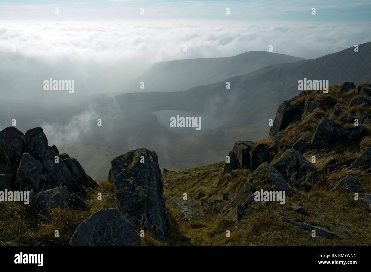 Llyn Lluncaws seen through mist and low cloud from the summit of Cadair ...