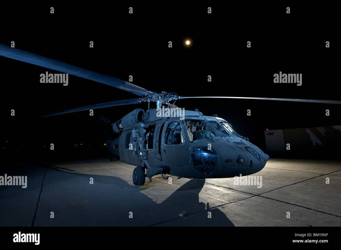A UH-60 Black Hawk helicopter lit up by multiple flash units under a ...