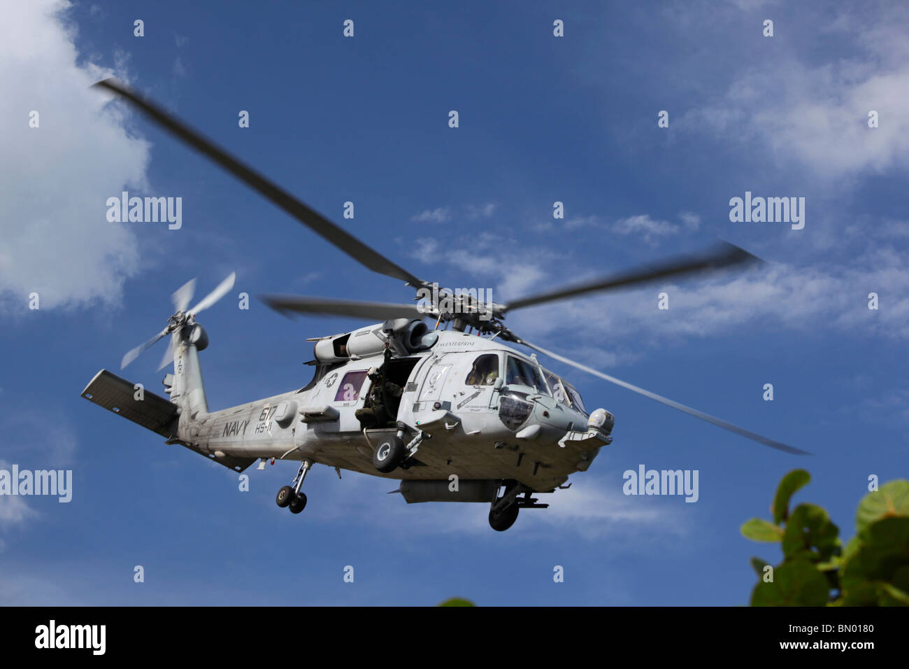 A Crew Chief looks out the side door of a helicopter in flight Stock ...