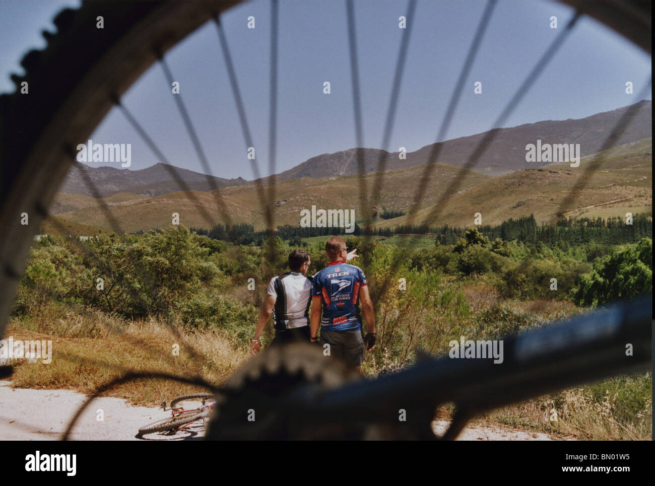 Cyclists through spokes of a bike wheel, Western Cape, South Africa ...