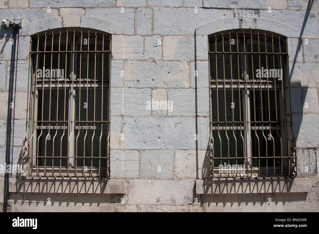 barred security windows stone building Stock Photo - Alamy