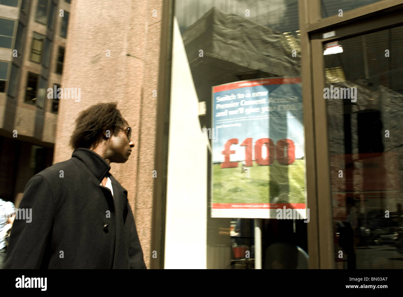 Black man looking at the advertisement in the London shop window ...