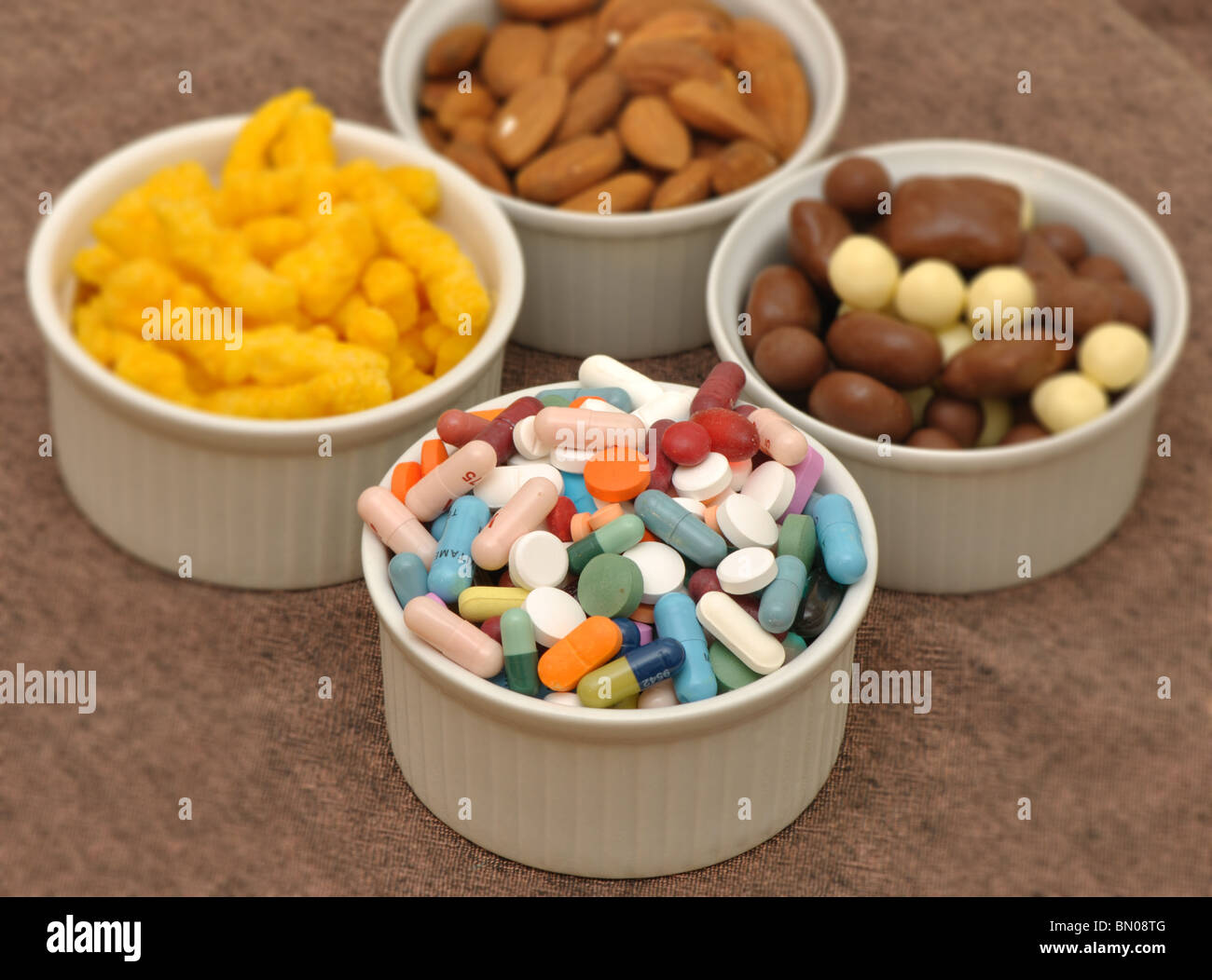 Medication pills served alongside traditional snacks Stock Photo - Alamy