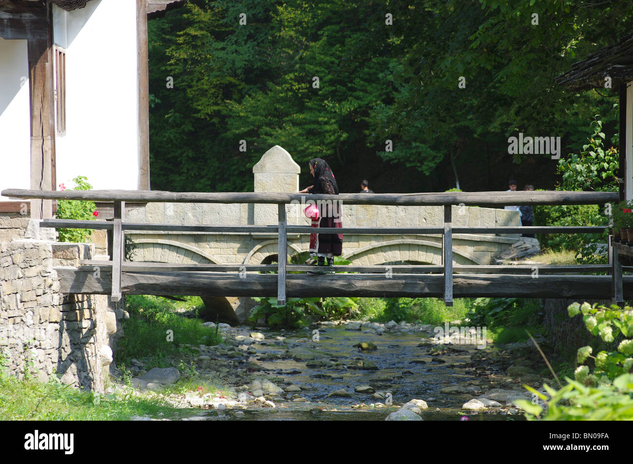Old woman passing by wooden bridge over a river Stock Photo - Alamy