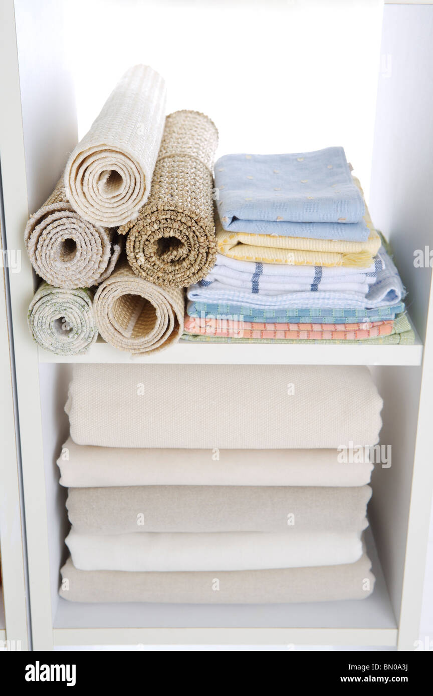 Clothes, Rugs stocked in a closet Stock Photo - Alamy