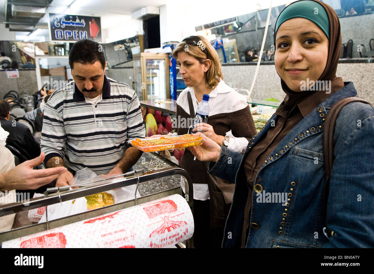 An Arab woman buying local sweets in a popular shop in the old city of ...