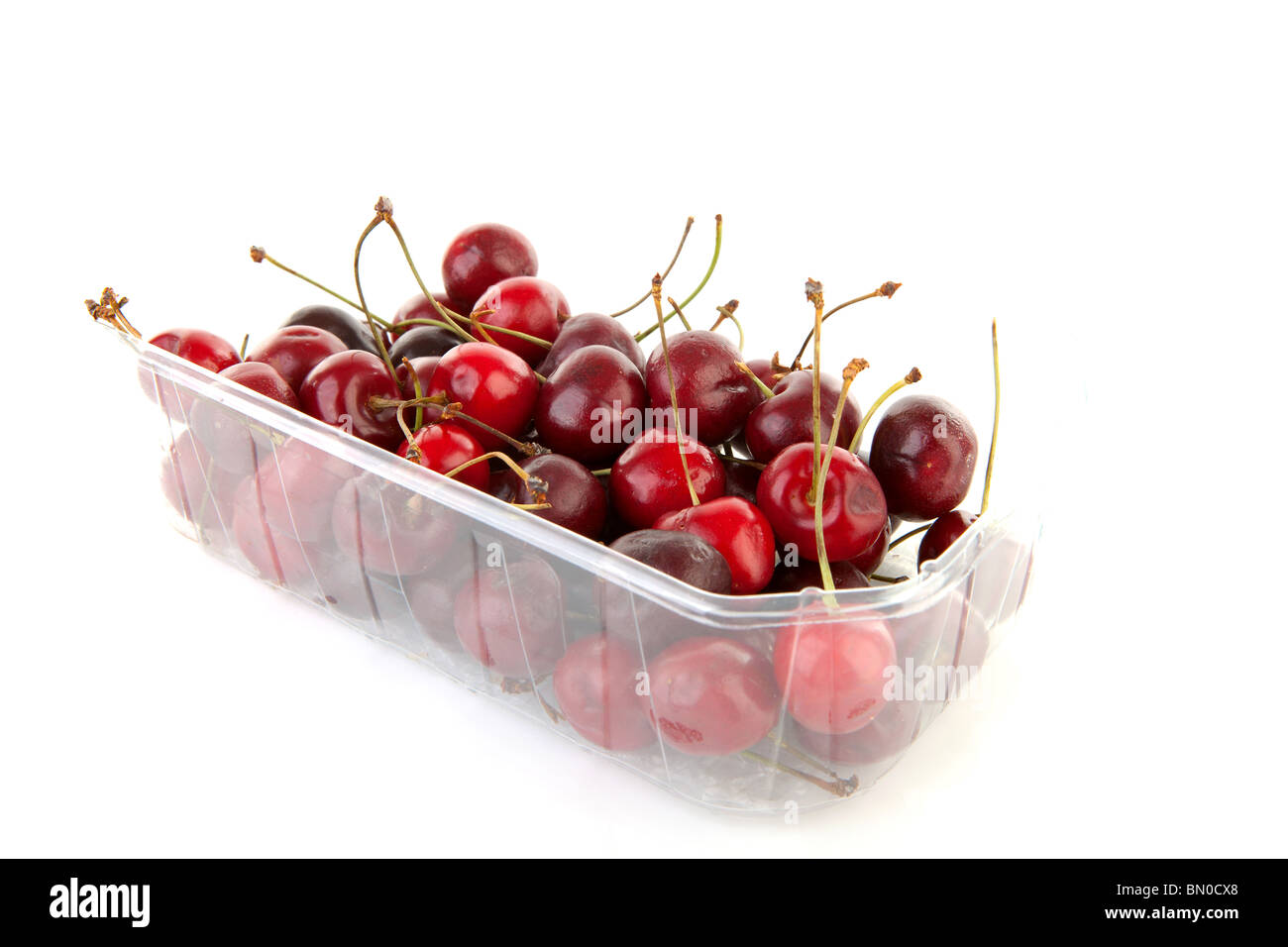 plastic container with cherries over white background Stock Photo - Alamy