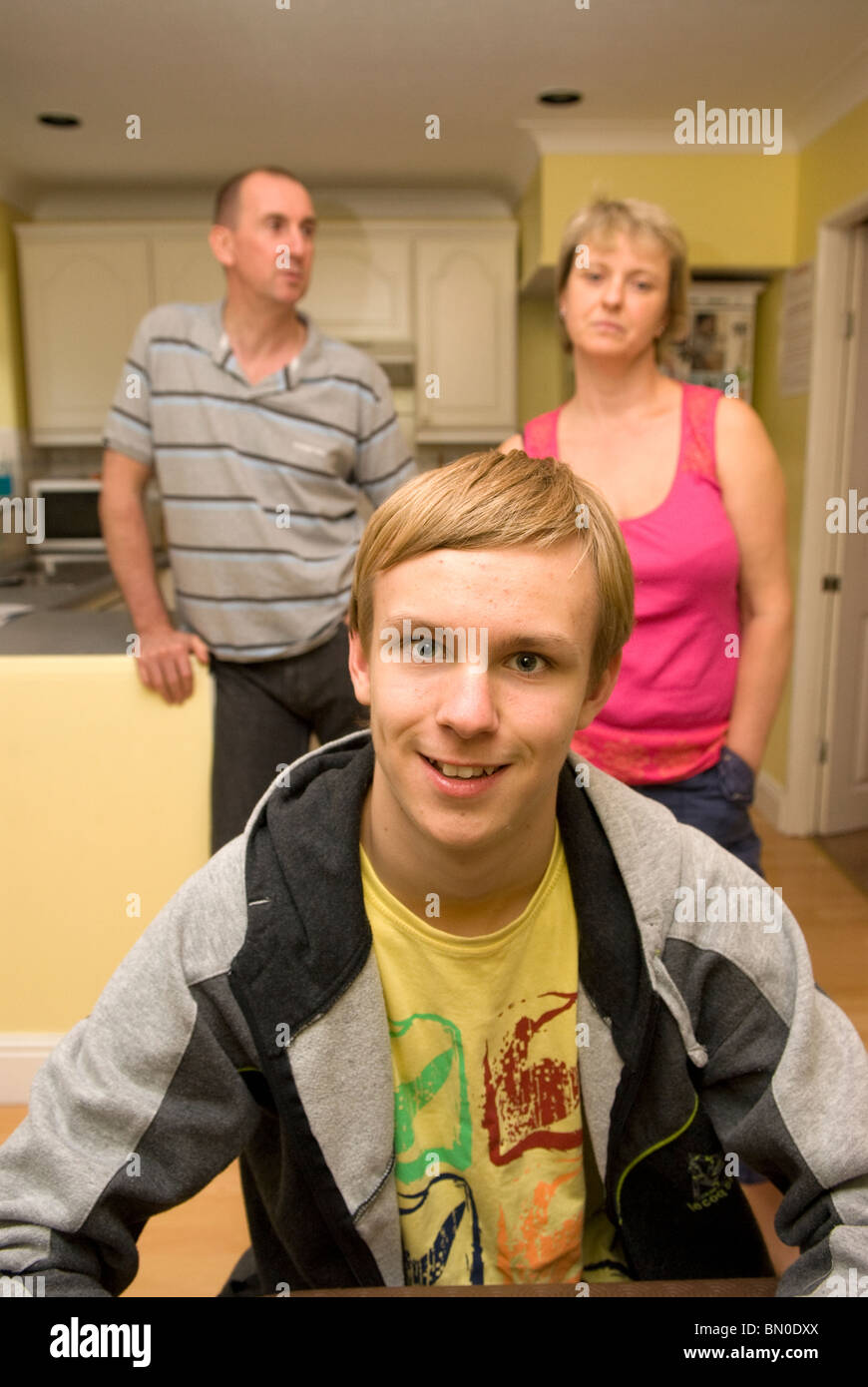 Young boy who has mild autism at home with his mum and dad in ...