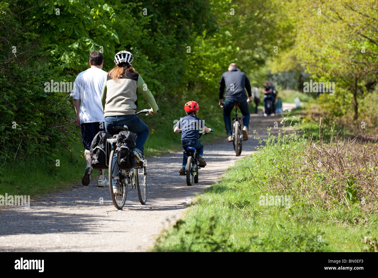 Family group cycling together on foot path Stock Photo - Alamy