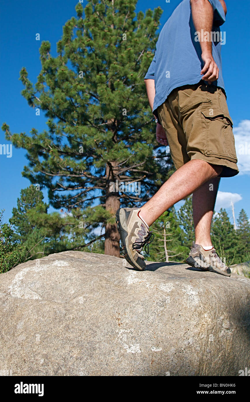 Trail runner climbing a steep rock in his path Stock Photo - Alamy