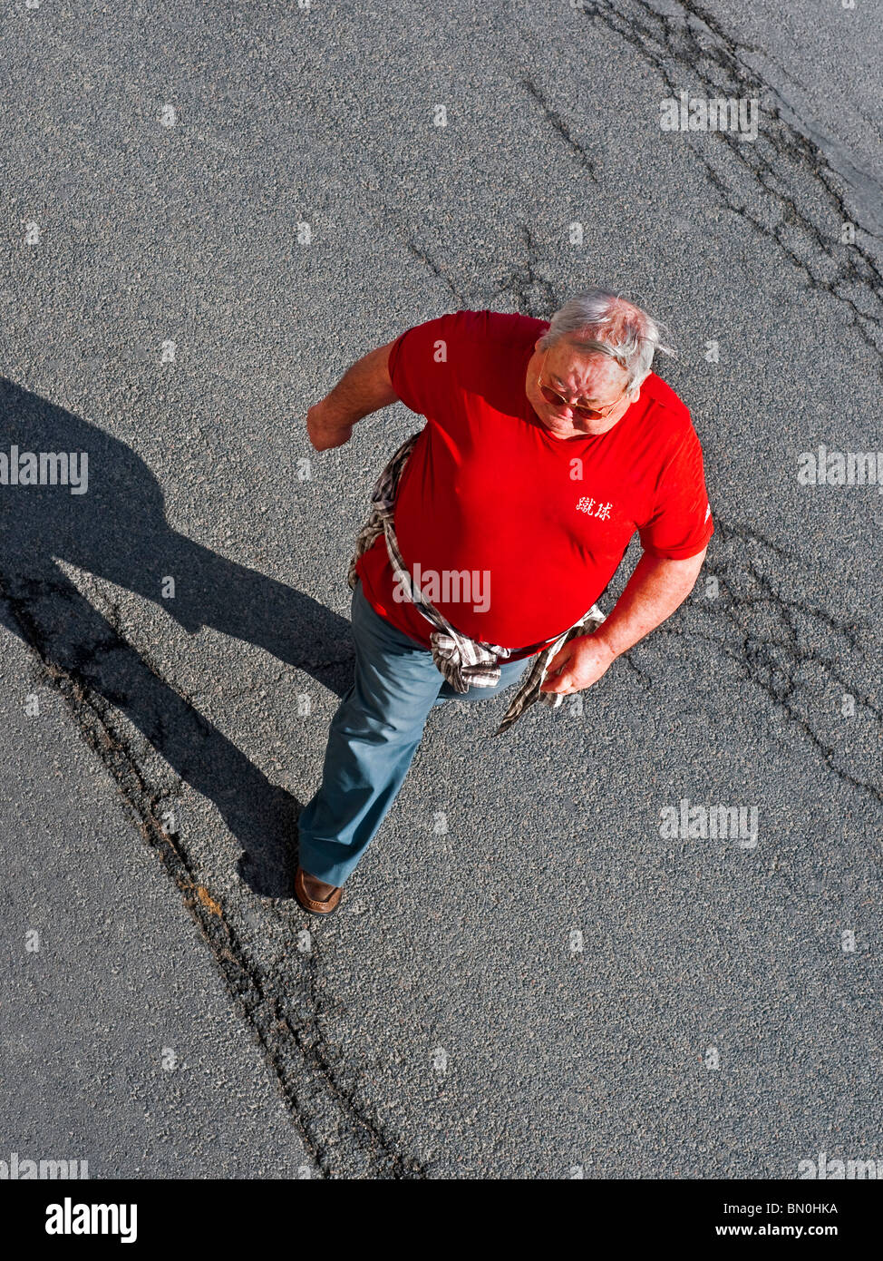 Overweight man walking across road / overhead view - France Stock Photo ...